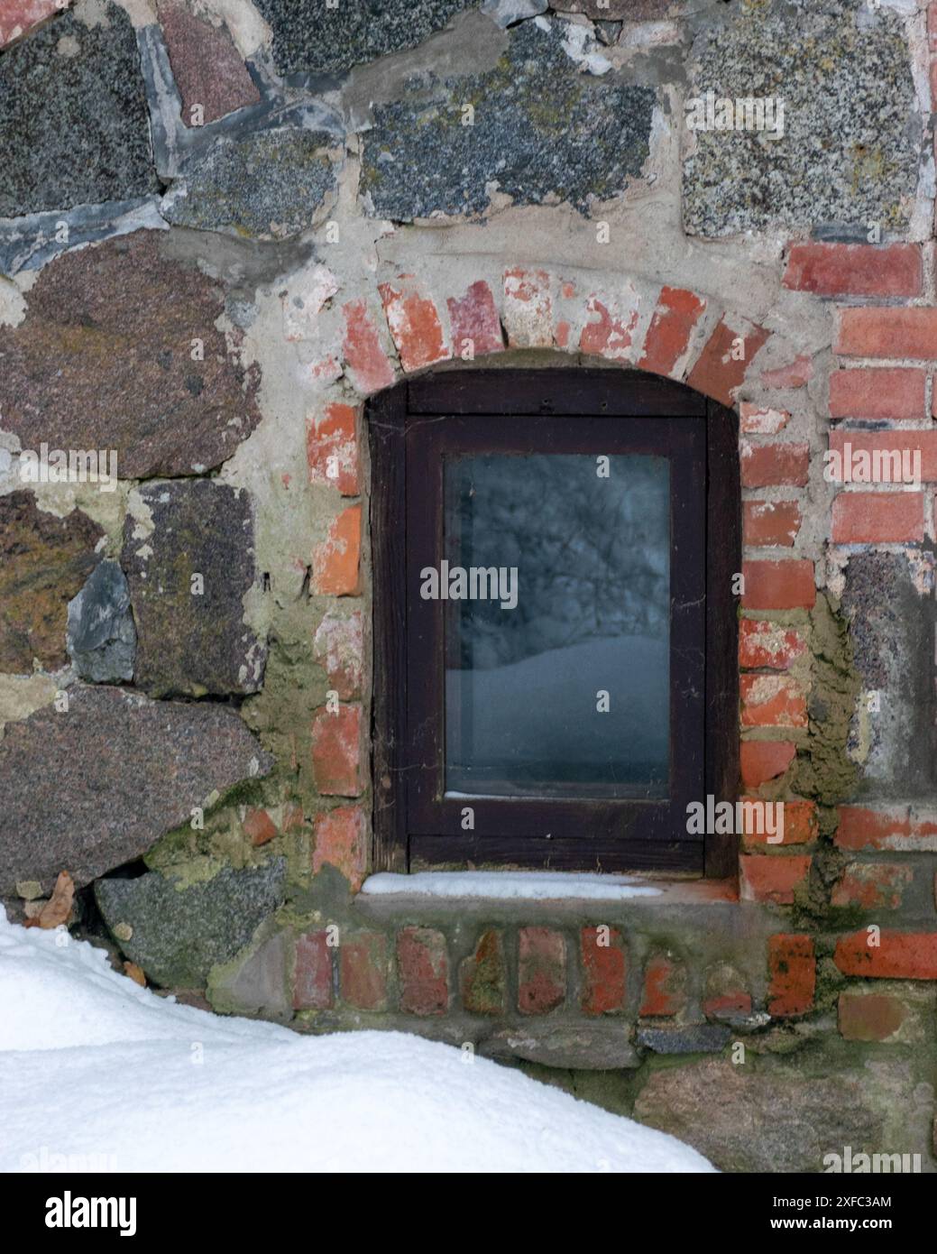 brick basement wall, window reflecting the winter view, old window in ...