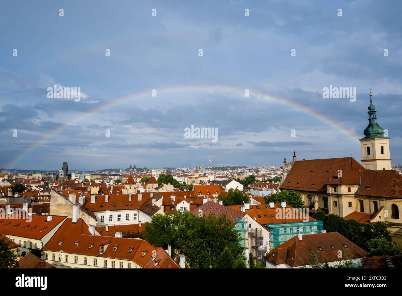 A rainbow seen over roofs of historical buildings in centre of Prague ...