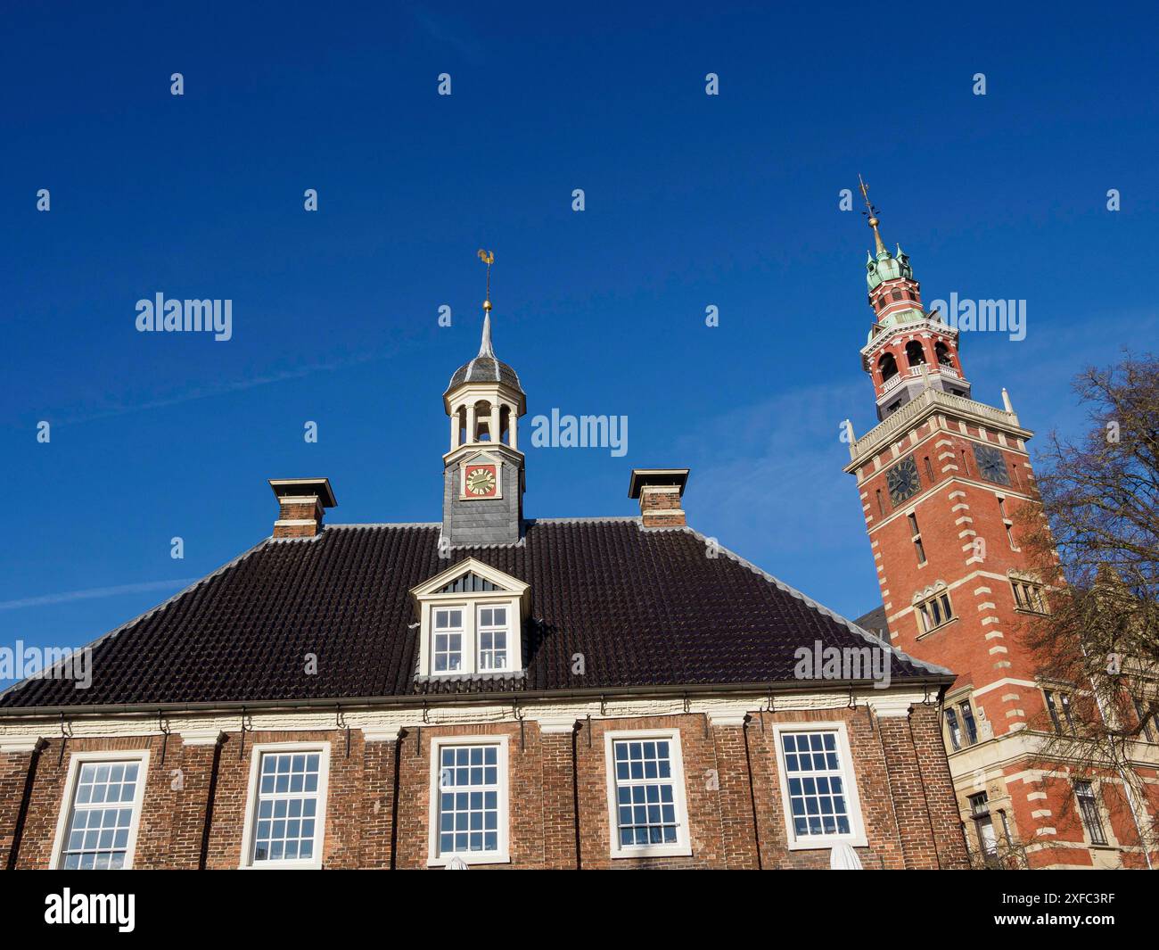 Old-fashioned building with clock tower and windows under a clear blue ...
