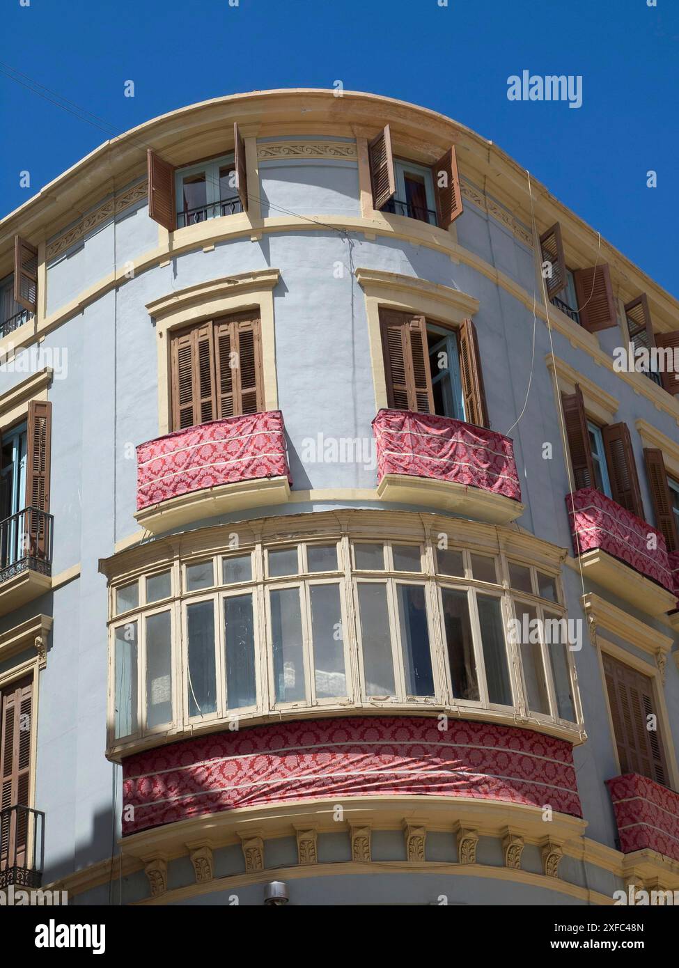 Building with balconies and protruding windows under a blue sky, malaga ...