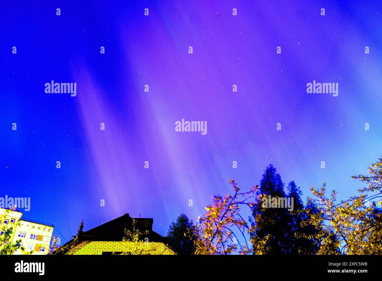 landscape with gorgeous northern lights over the roof of the house ...