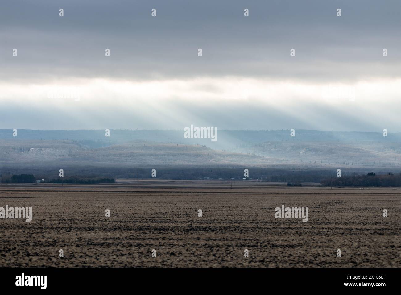 Sun rays shining down brightly over the Canadian prairie lands of ...