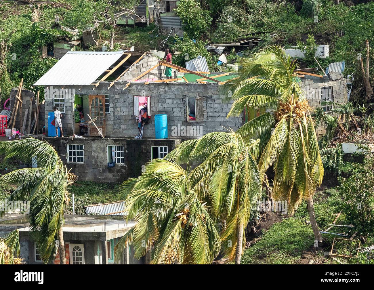Family members begin to repair their home damaged in the passing of ...