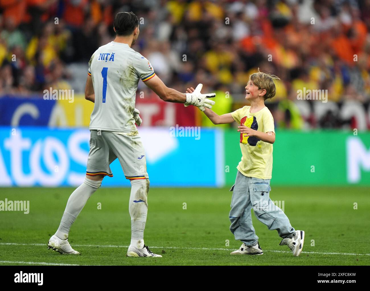 A pitch invader greets Romania goalkeeper Florin Nita (left)during the ...