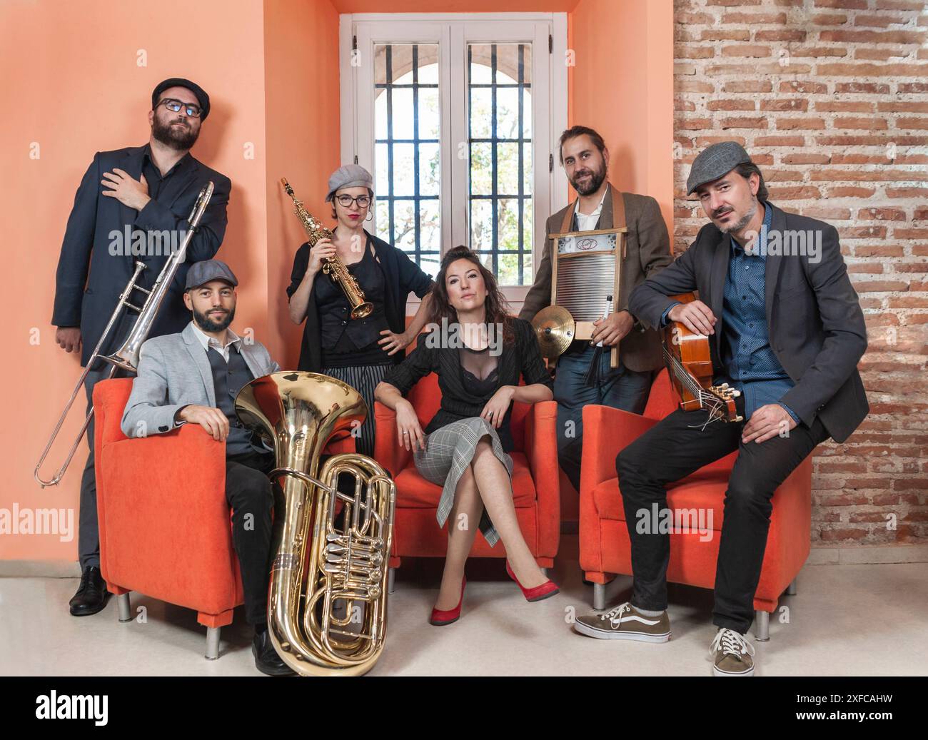 Jazz band composed of 6 members, posing seated on an orange armchair in ...