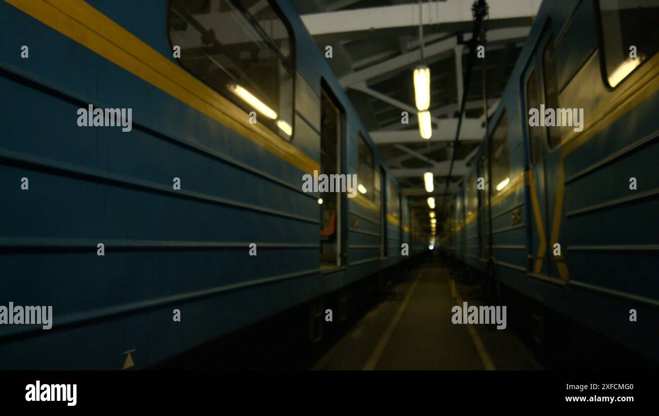 A modern metro train stands in the depot. Train cars are lined up along ...
