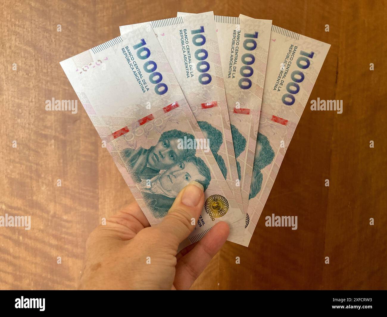 hand holds new 10.000 Argentine peso bills of Central Bank of the ...