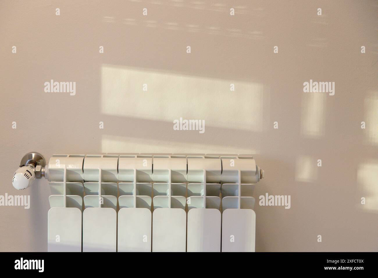 Warm sunlight filters through a window, casting soft shadows on a wall ...