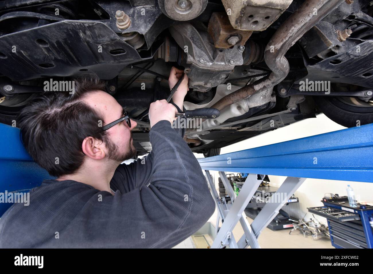 automotive mechanic works on the car to fix a problem automotive ...