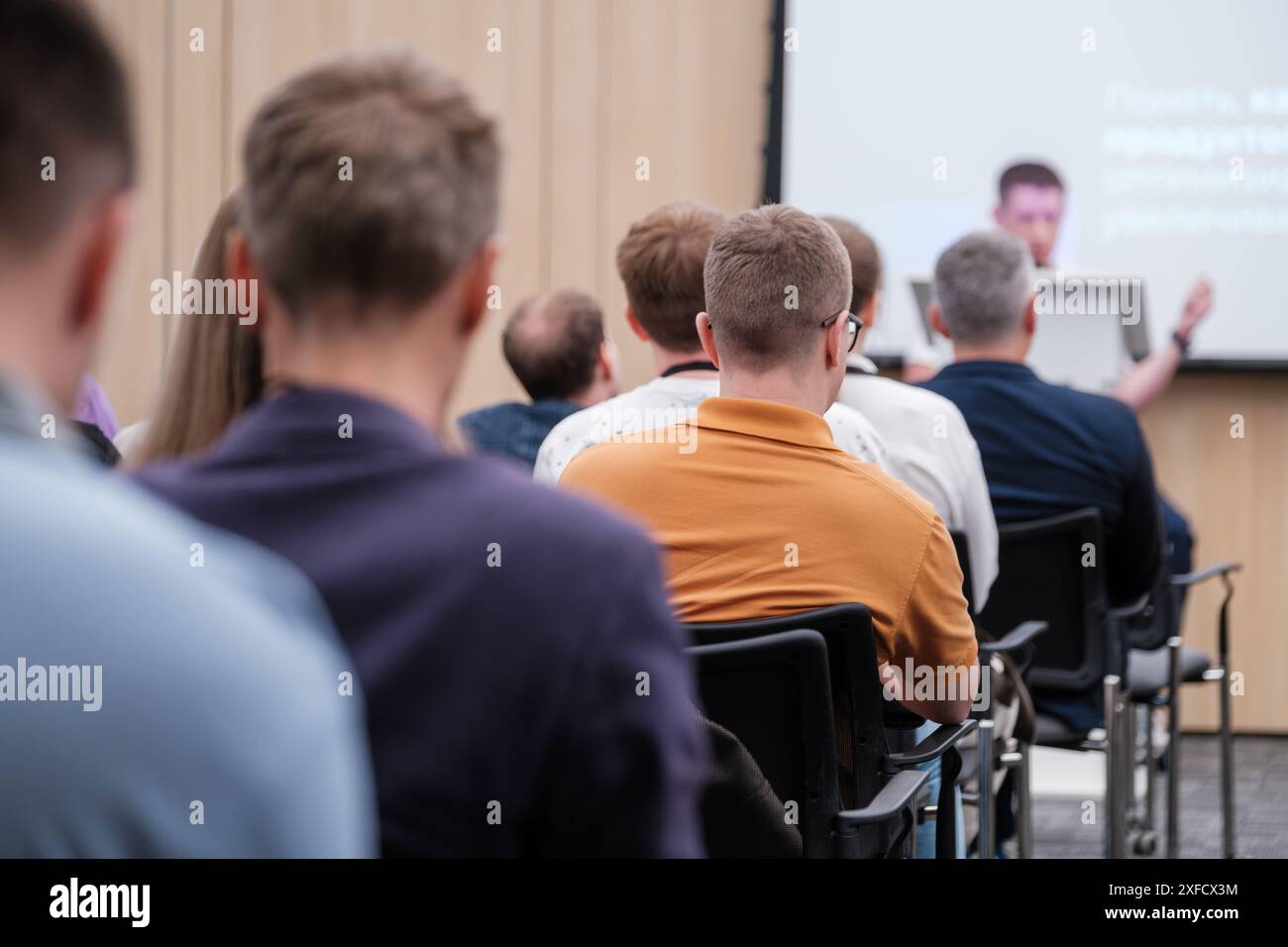 Group of people attending a tech conference, listening to a speaker ...