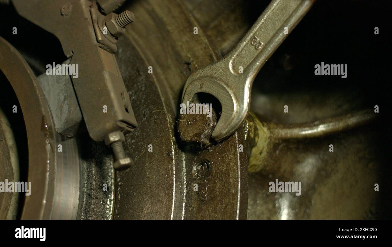 Engine repair. Mechanic tightening the screws. Repair of equipment ...