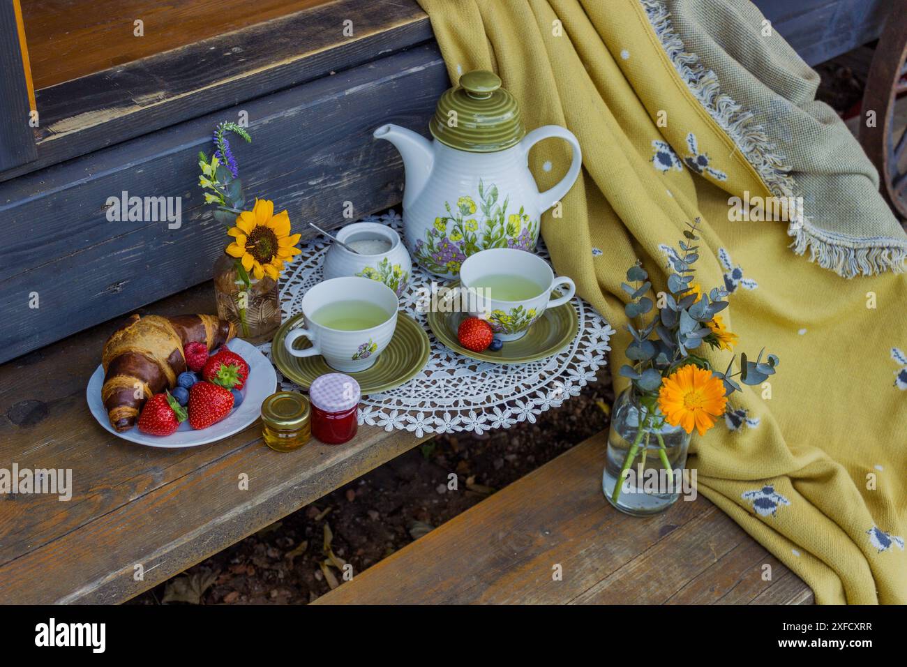 Morning summer tea with flowers and fruits on the veranda in the ...