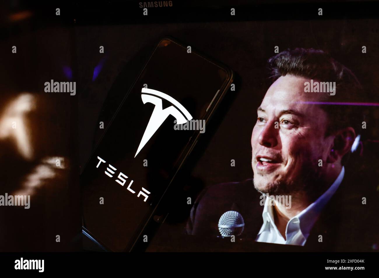 In this photo illustration, the Tesla logo is seen displayed on a ...