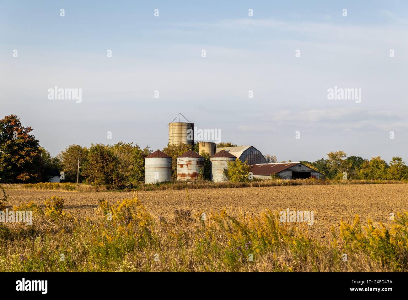 Rustic farmland scene - clear blue sky, plowed field in foreground ...