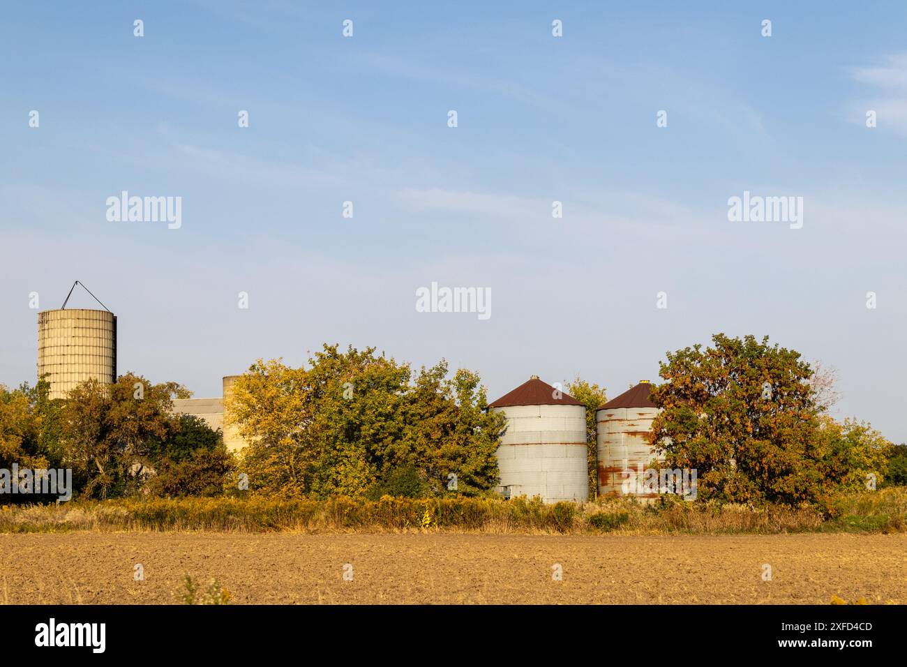 Rustic farmland scene - clear blue sky, plowed field in foreground ...
