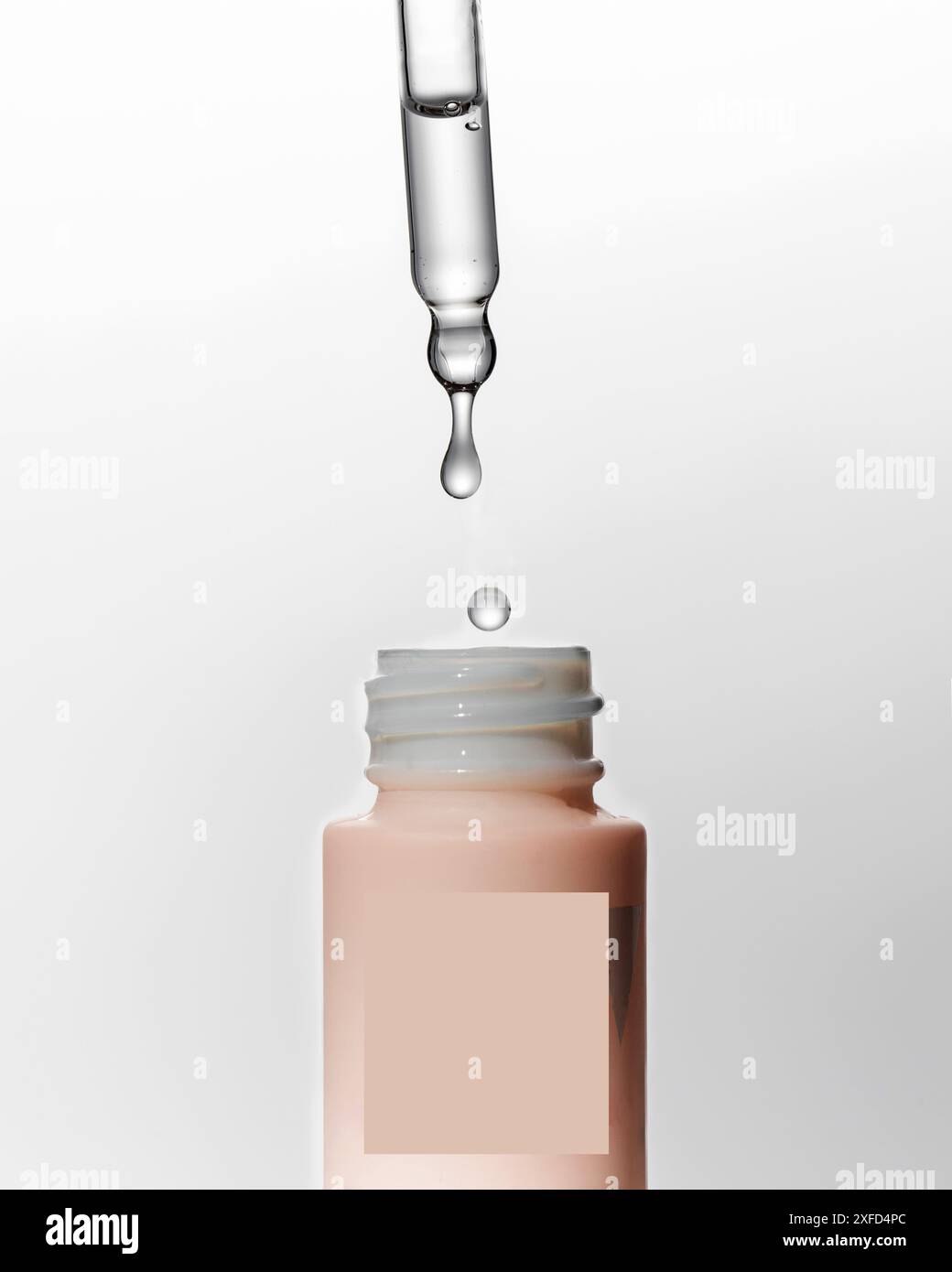 Hyaluronic acid drops fall from pipette into mockup bottle Stock Photo ...