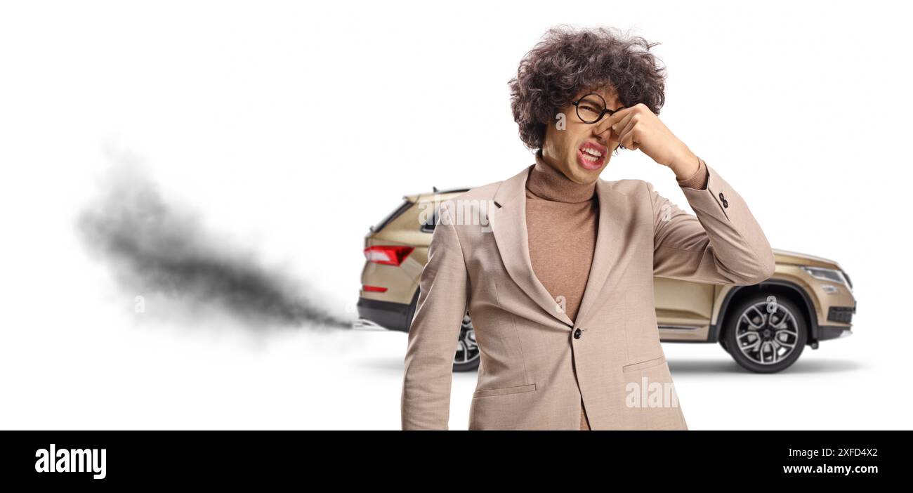 Young man in front of a vehicle disgusted from exhaust fume isolated on ...