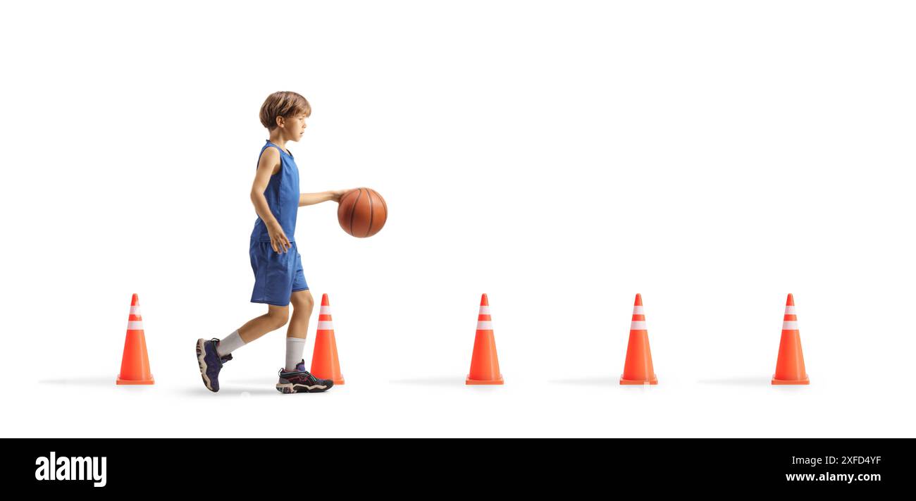 Boy with a basketball training with obstacle cones isolated on white ...