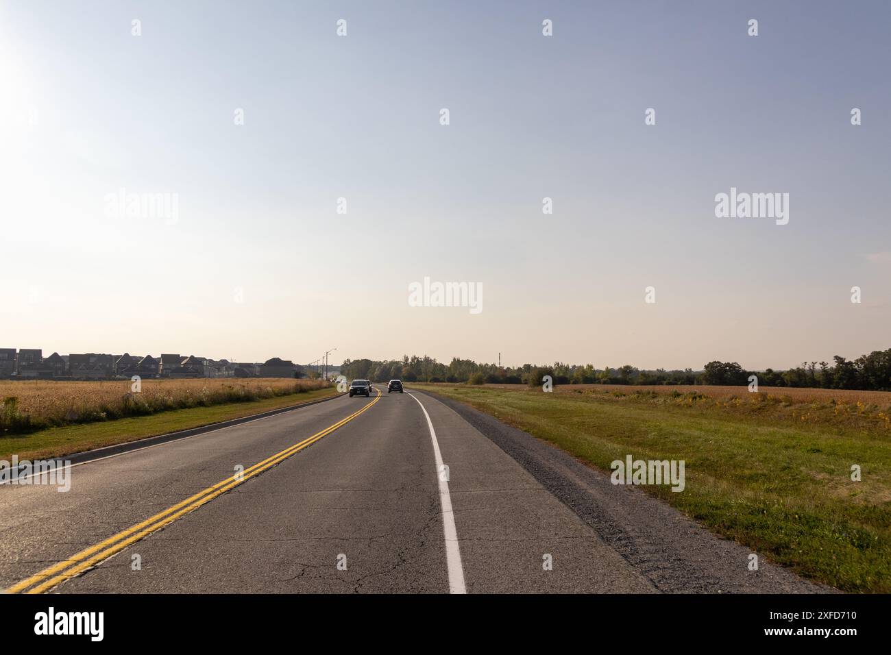 Open road ahead, bright sunshine - car journeying into distance - lush ...