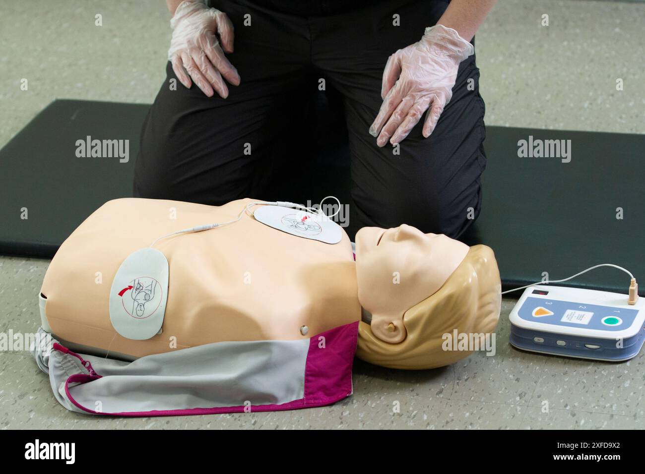 First responce worker demonstrades CPR and proper defibrillator procedure on a manikin Stock ...