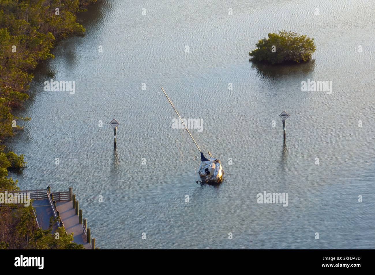 Aerial view of sunken sailboat on shallow bay waters after hurricane in ...