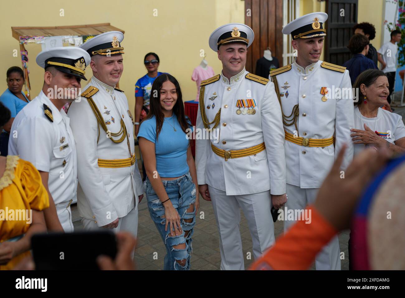 Russian crew members pose for a photo with a girl during a welcoming ...