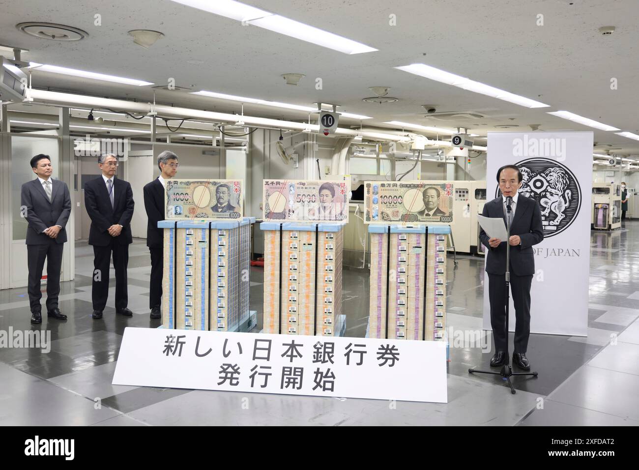Bank of Japan's governor Kazuo Ueda (R) delivers a speech as new ...