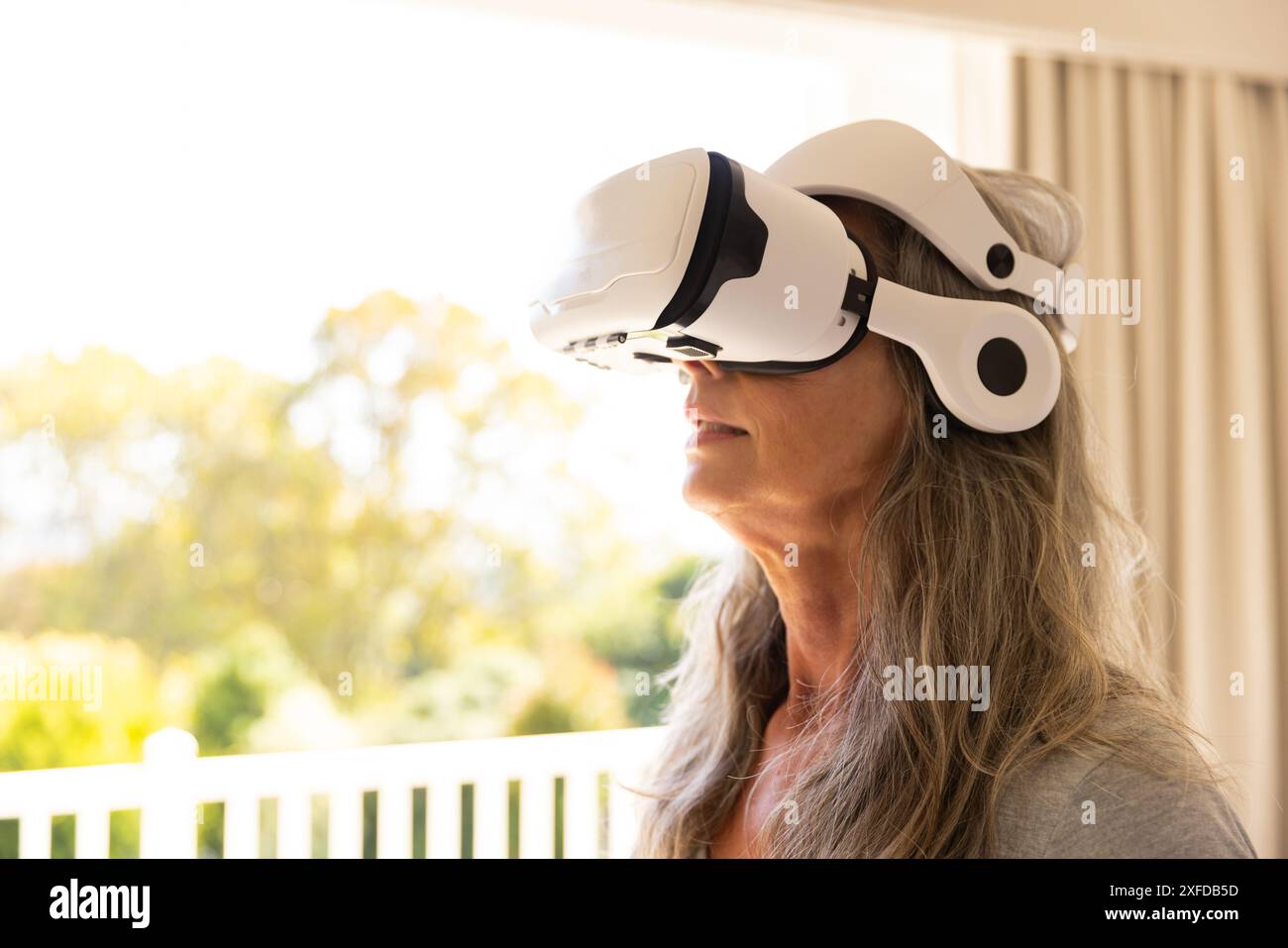 Using VR headset, mature woman exploring virtual reality at home Stock ...