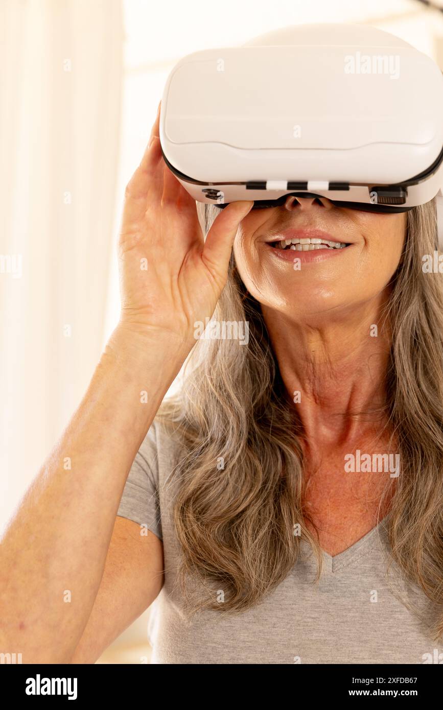 Using VR headset, mature woman exploring virtual reality at home Stock ...