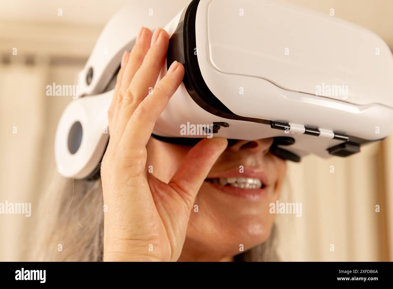 Using VR headset, mature woman exploring virtual reality at home Stock ...
