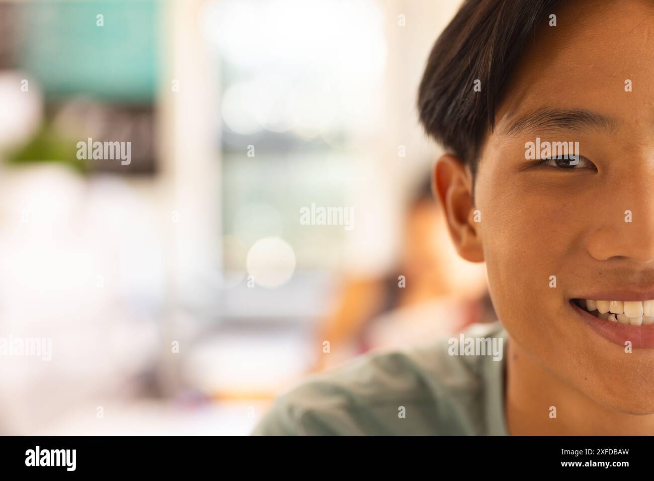 Smiling teenage boy in high school classroom, focusing on studies and ...