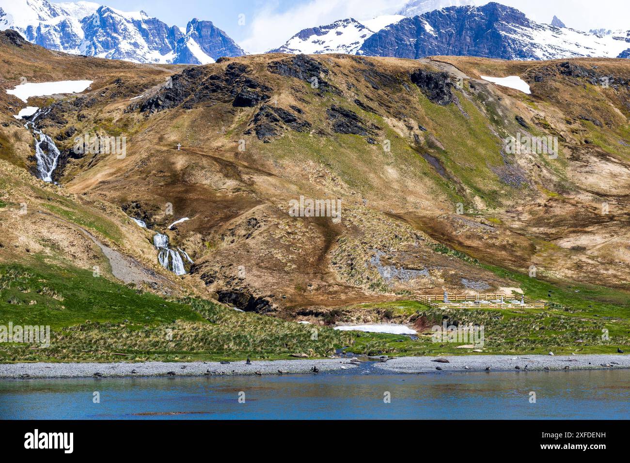 Cemetery, two white crosses on hill, waterfall and grassy hillside ...