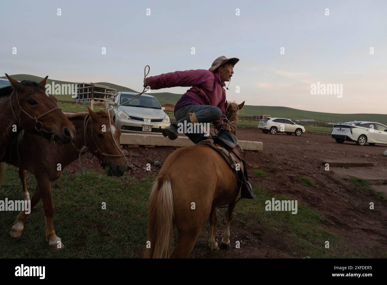 A Mongolian horseman leaps onto his horse on the outskirts of Ulaanbaatar, Mongolia, Monday ...
