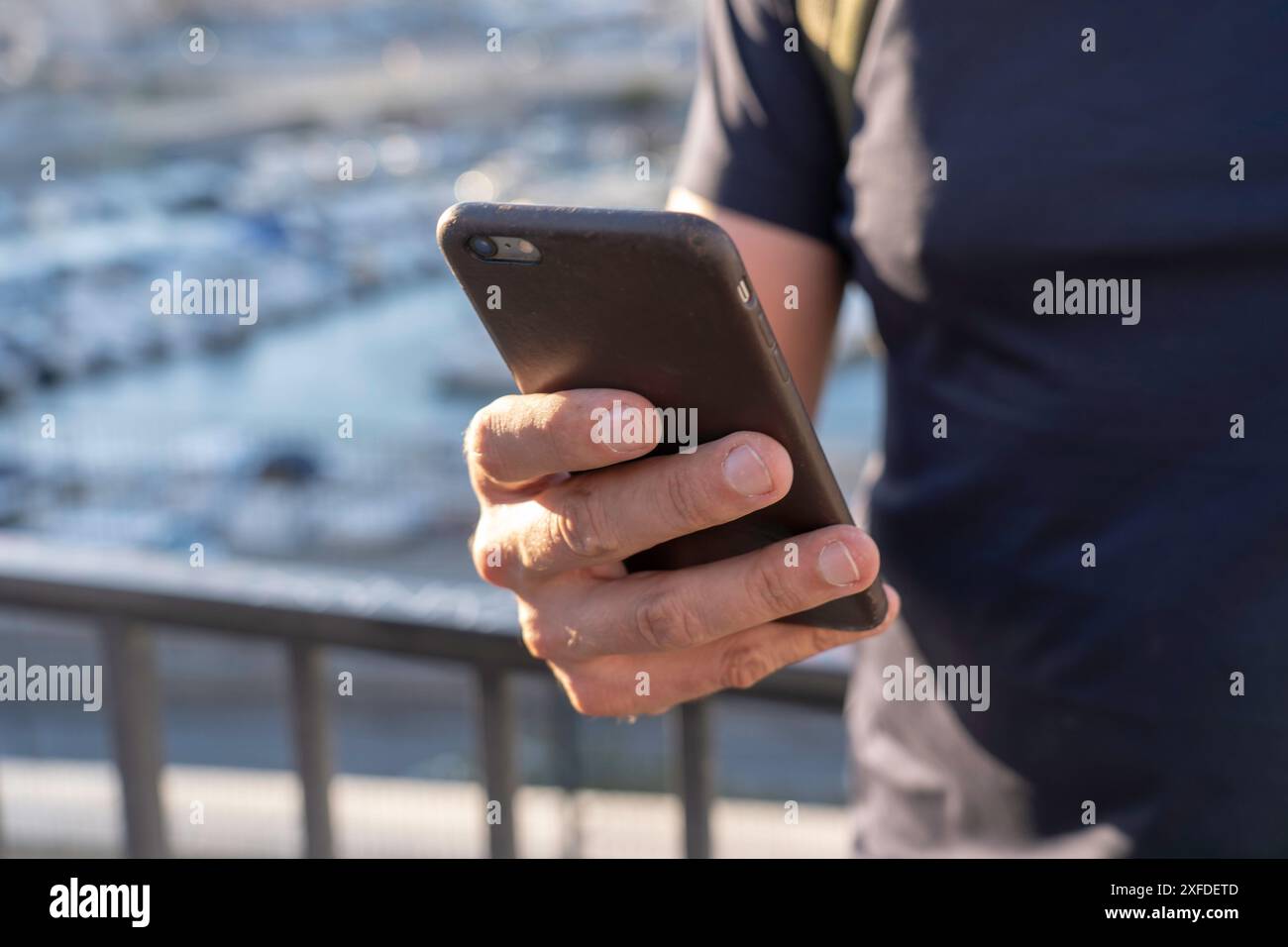 Close up view of a man holding and using his mobile phone to keep ...