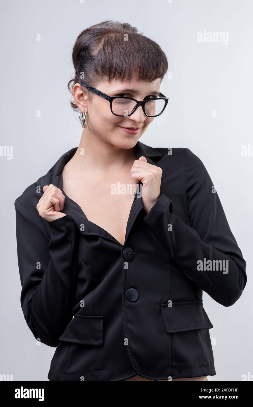 woman with a mischievous gaze and playful pose, pulling at her jacket ...