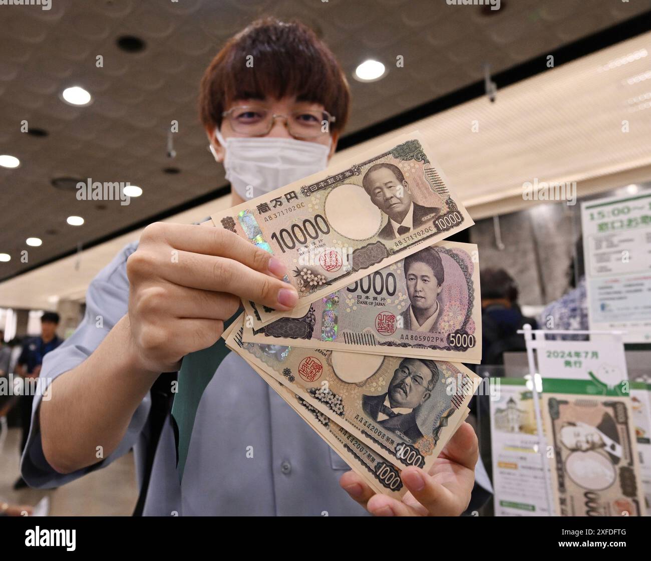 A man shows three types of new banknotes which were issued for the ...