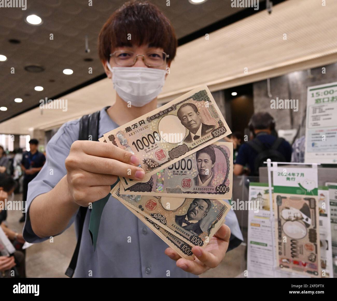 A man shows three types of new banknotes which were issued for the ...
