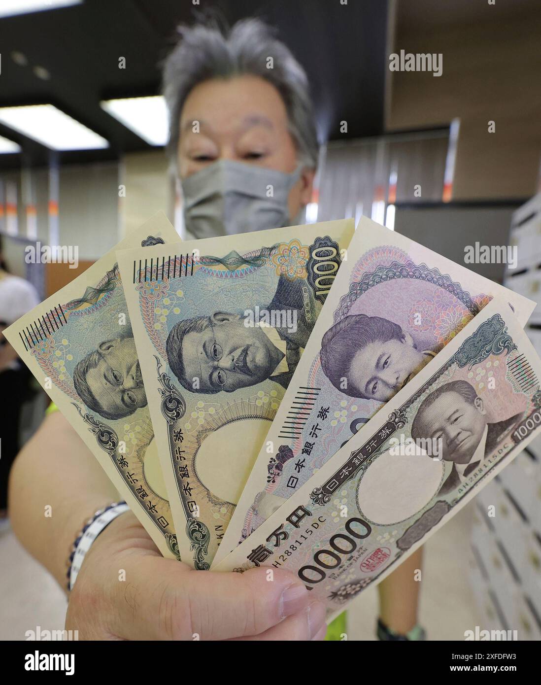 A man shows three types of new banknotes which were issued for the ...