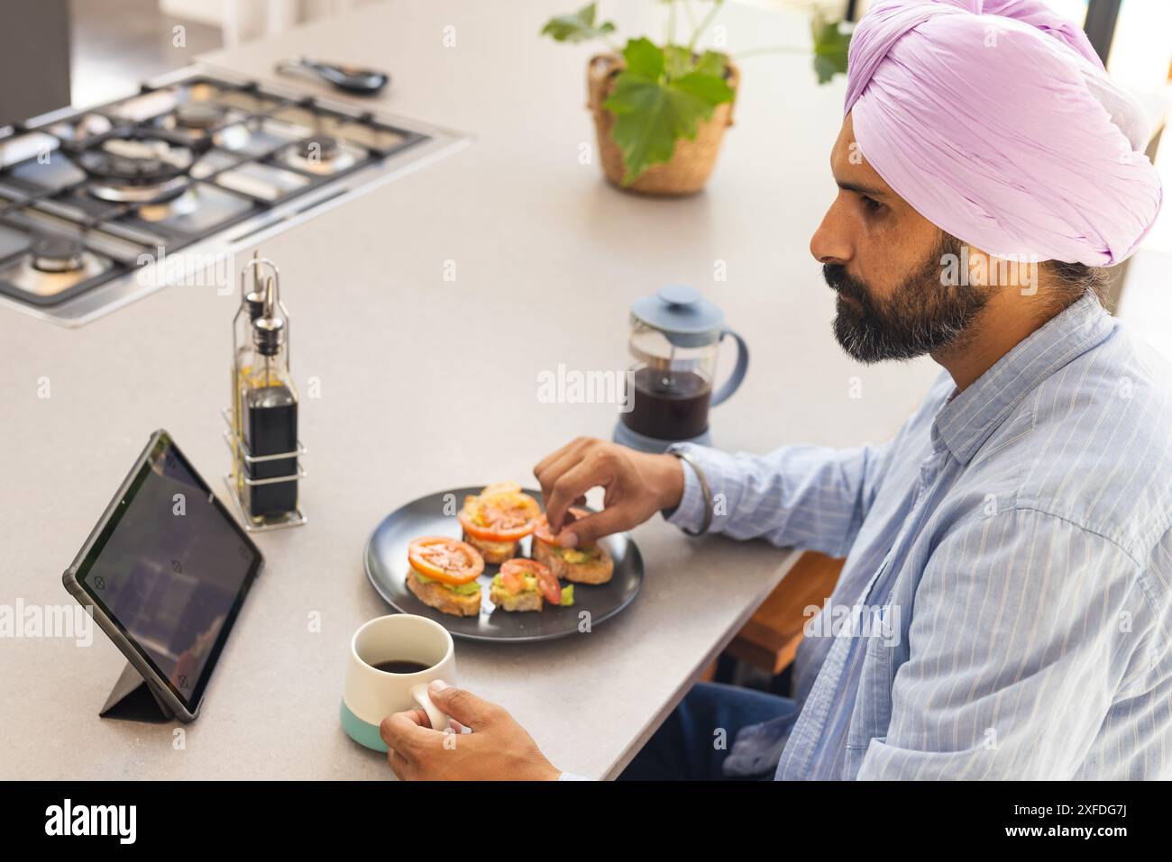 Eating breakfast, man watching tablet and drinking coffee in kitchen ...