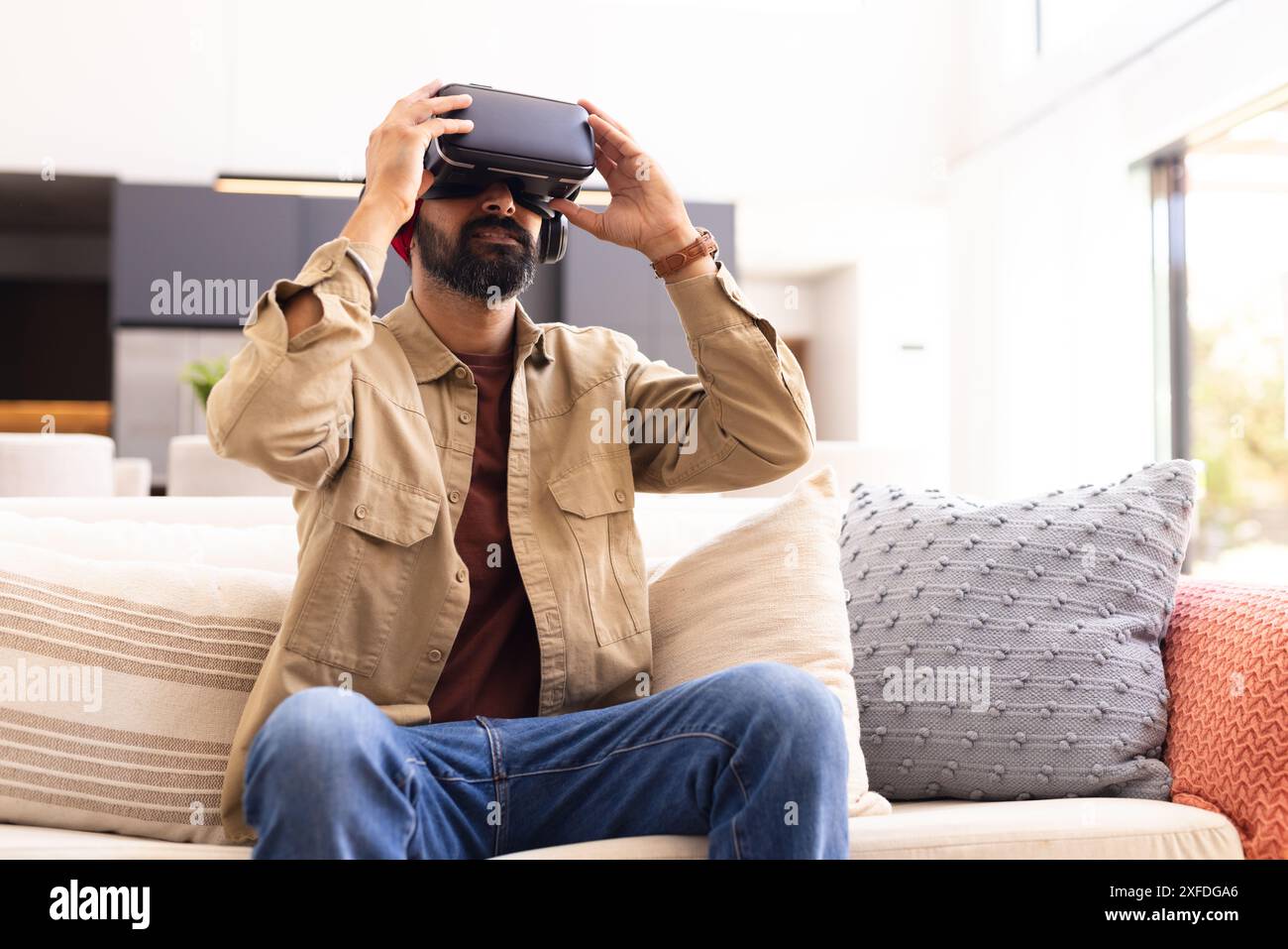 Using VR headset, man sitting on couch and exploring virtual reality at ...