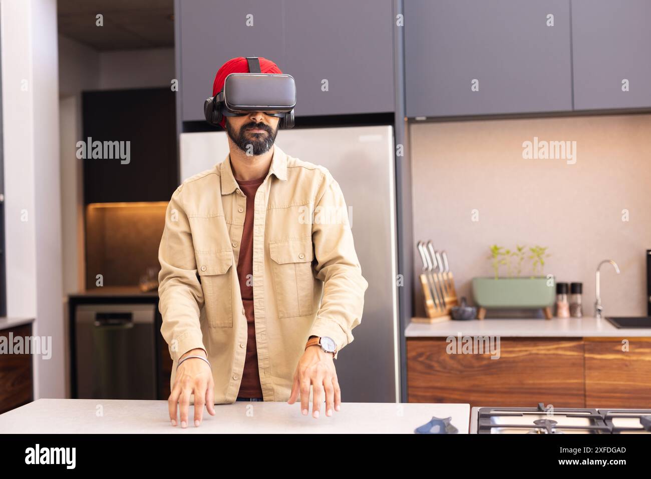 Using VR headset, man exploring virtual reality in modern kitchen, copy ...