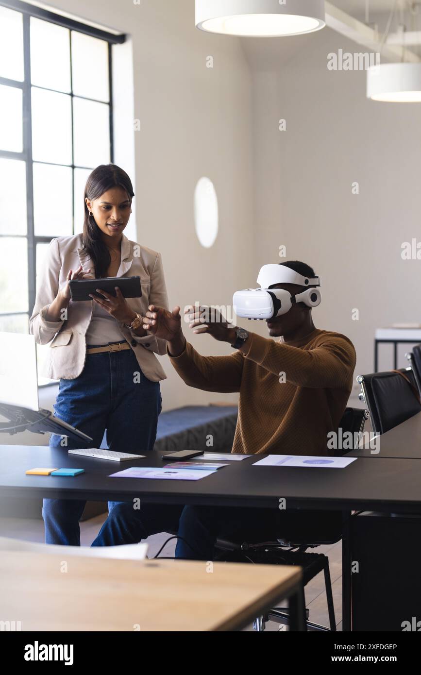 Using VR headset, man interacting with virtual environment while woman observes Stock Photo - Alamy