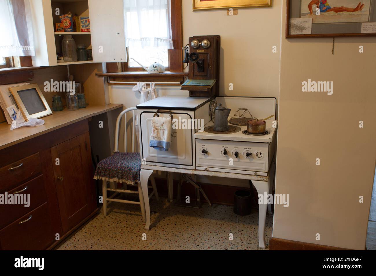 Kitchen with old appliances and telephone, goods in cupboards ...