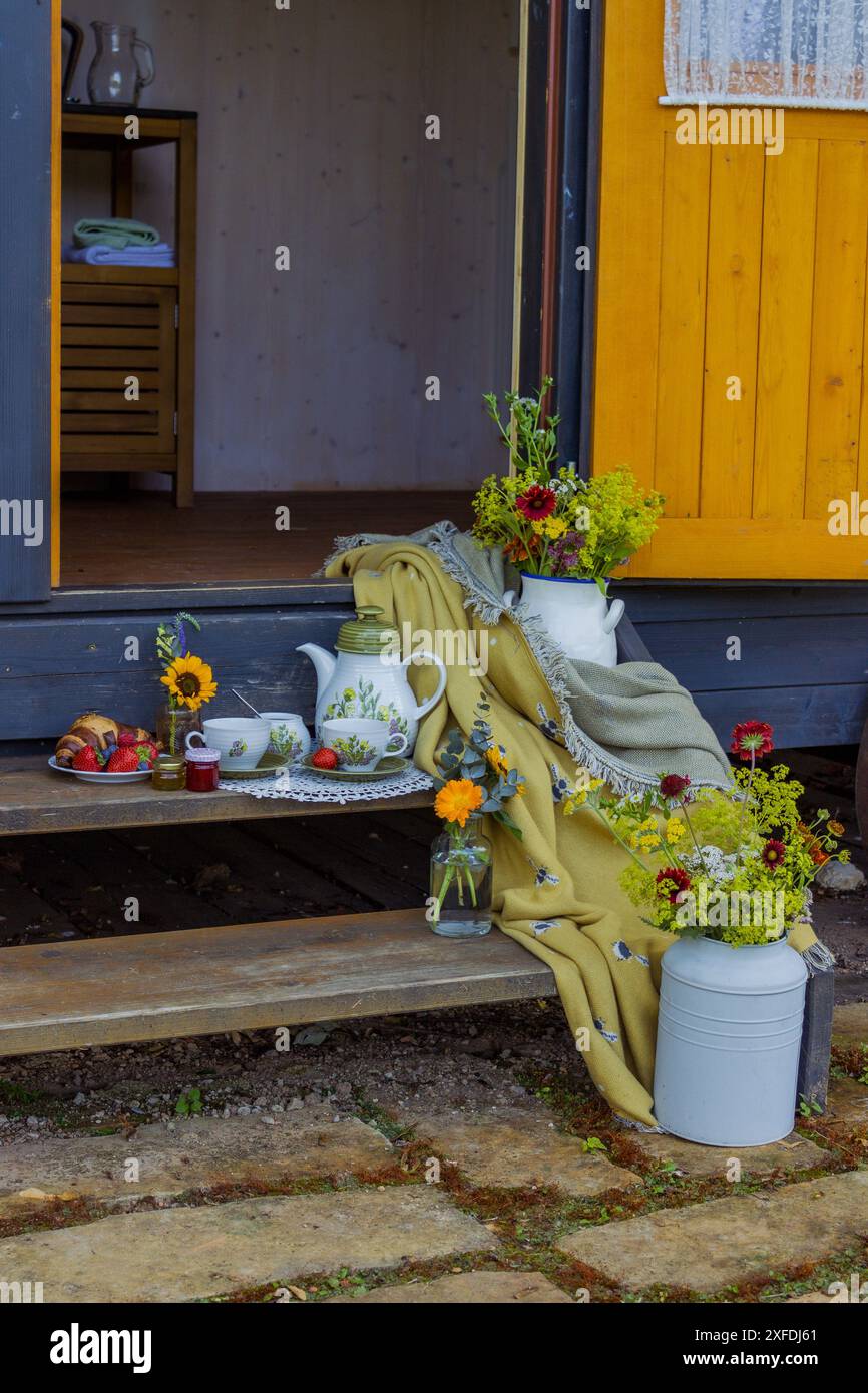 Morning summer tea with flowers and fruits on the veranda in the ...