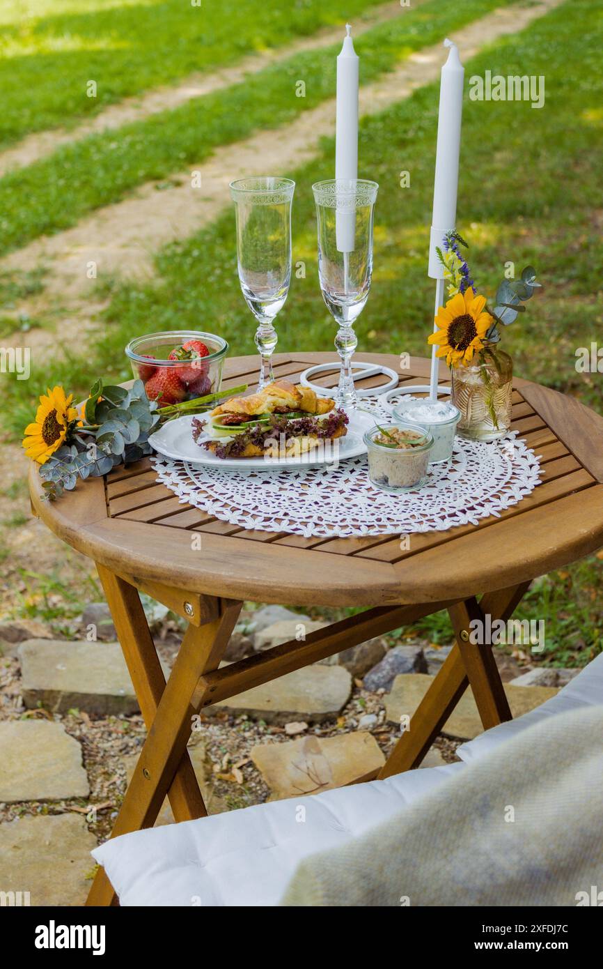 Summer table with wine and snacks fruit and croissants rustic landscape ...