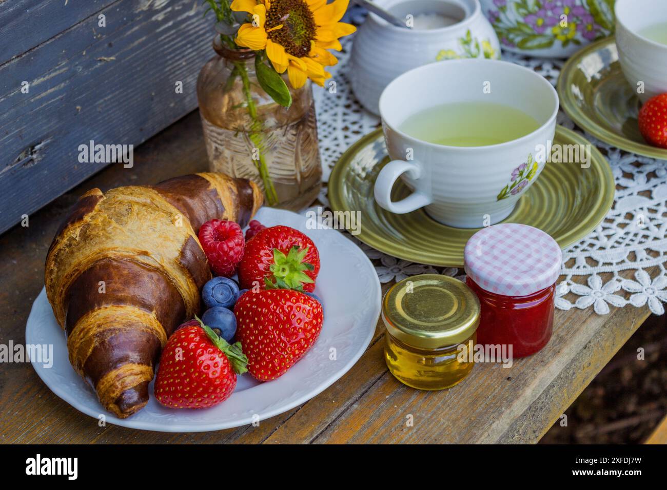 Morning summer tea with flowers and fruits on the veranda in the ...