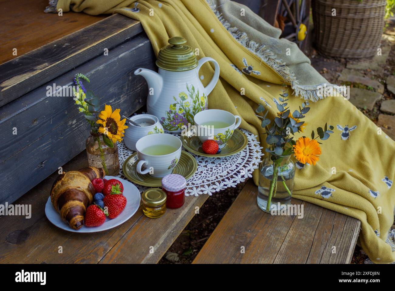 Morning summer tea with flowers and fruits on the veranda in the ...