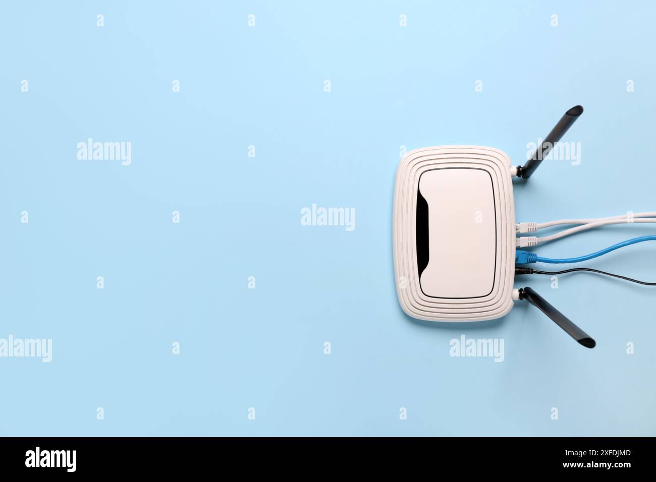 Modern wi-fi router with cables on blue background Stock Photo - Alamy