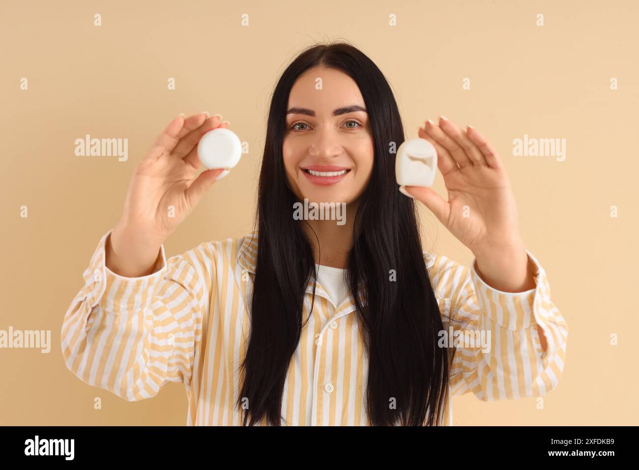 Beautiful young happy woman with different dental floss on beige ...