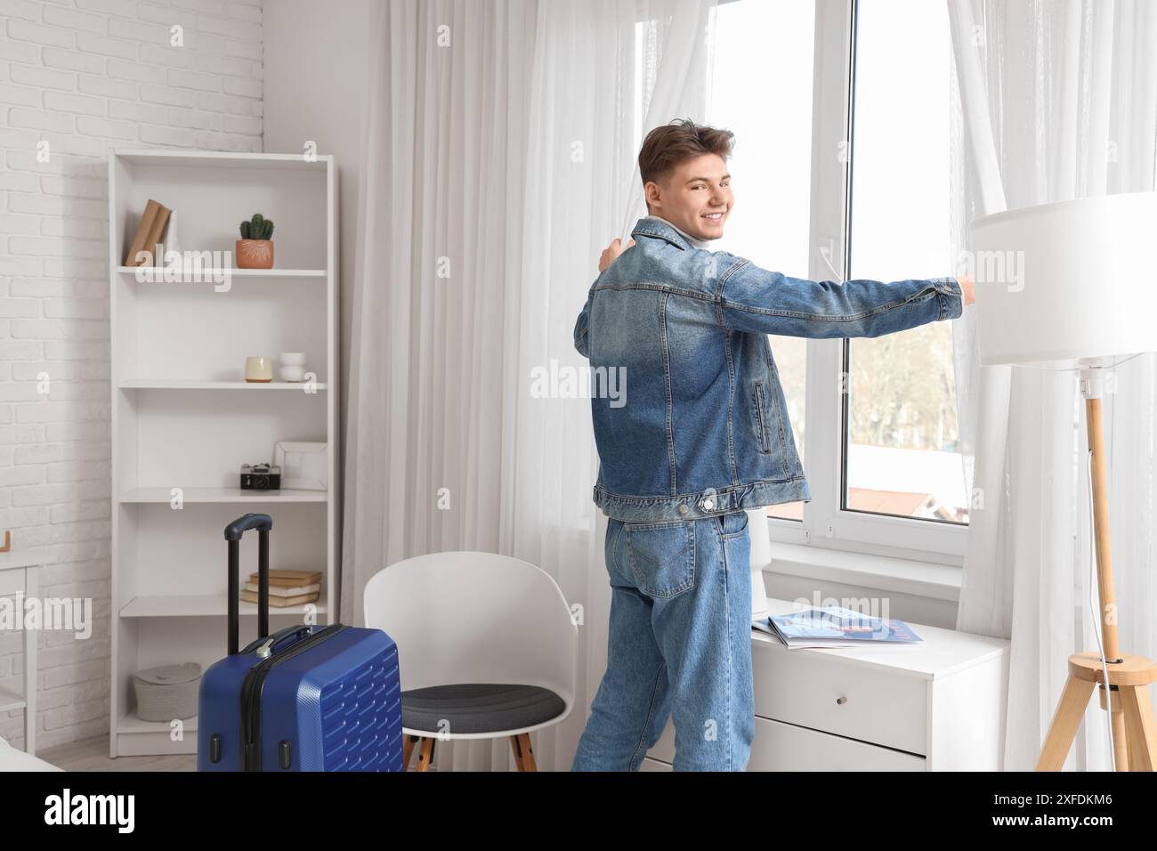 Young man opening curtains hi-res stock photography and images - Alamy